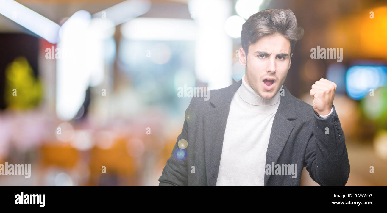 Young elegant man wearing winter coat over isolated background angry ...