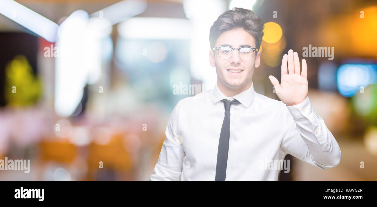 Young business man wearing glasses over isolated background Waiving ...