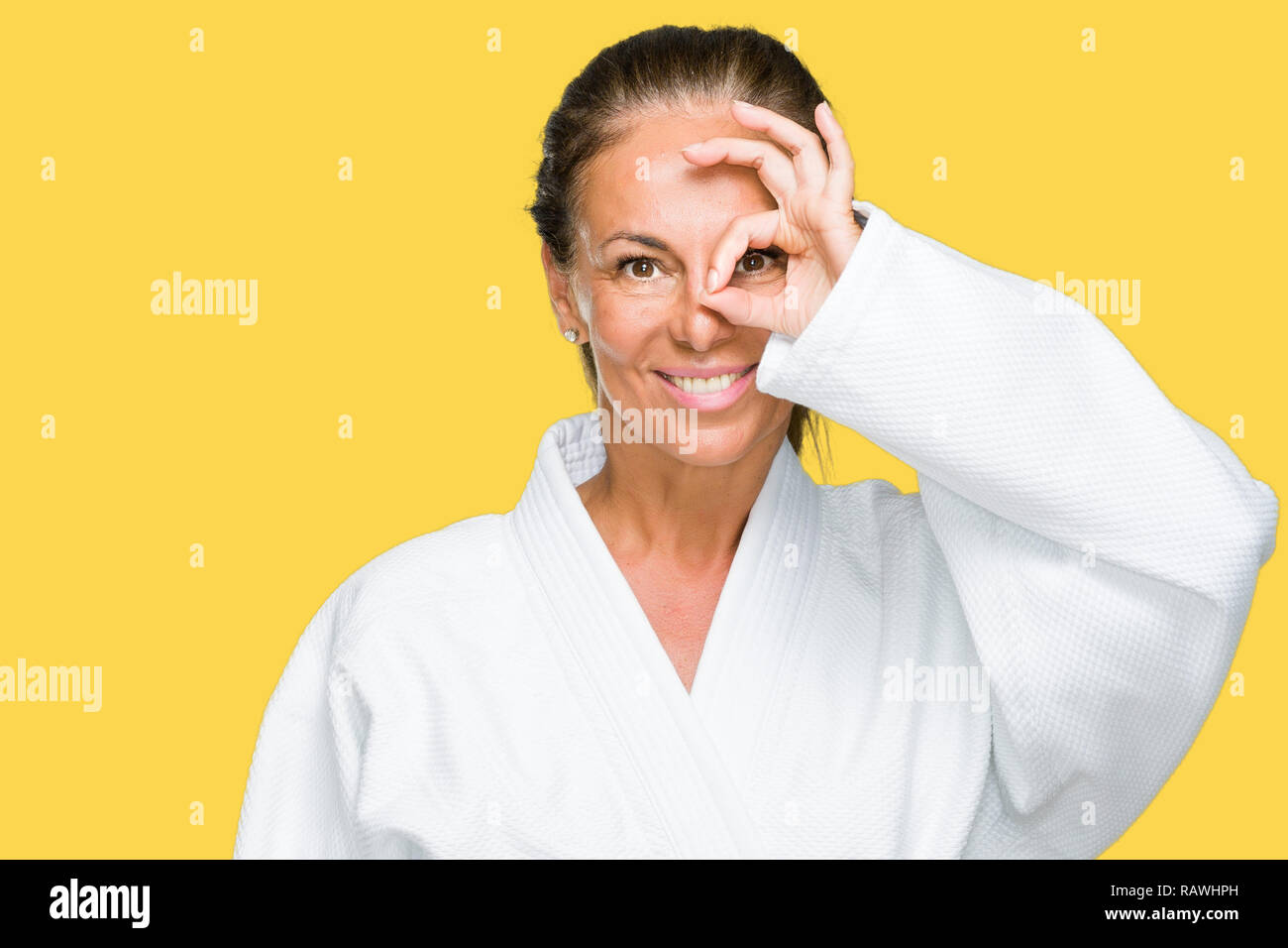 Middle age adult woman wearing karate kimono uniform over isolated ...