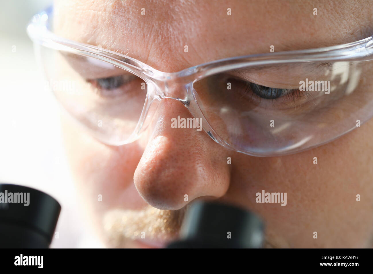 Male scientist looking through binocular Stock Photo - Alamy