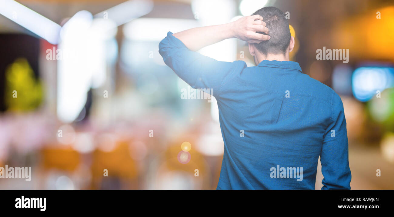 Young handsome man over isolated background Backwards thinking about ...