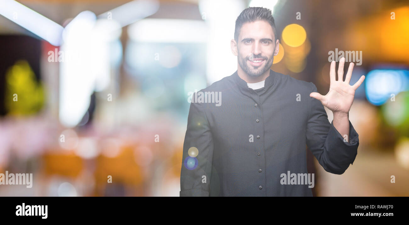 Young Christian priest over isolated background showing and pointing up ...