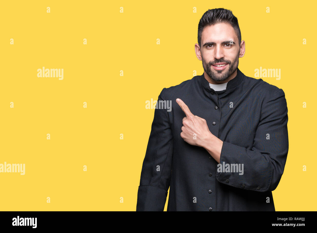 Young Christian priest over isolated background Pointing with hand ...
