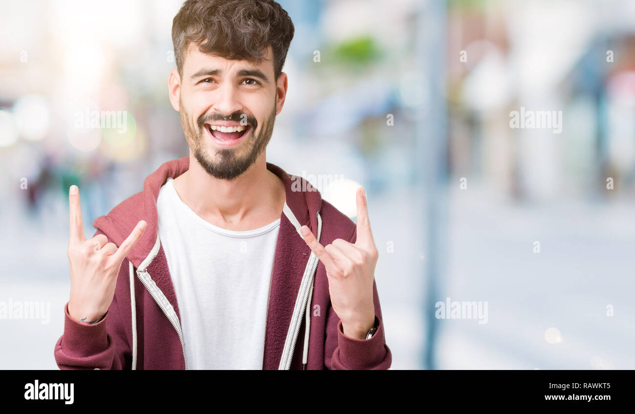 Young handsome man over isolated background shouting with crazy ...