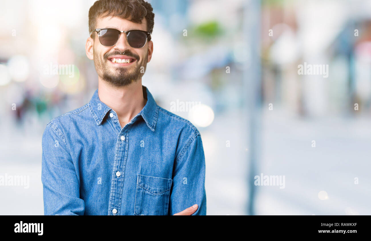Young handsome man wearing sunglasses over isolated background happy ...