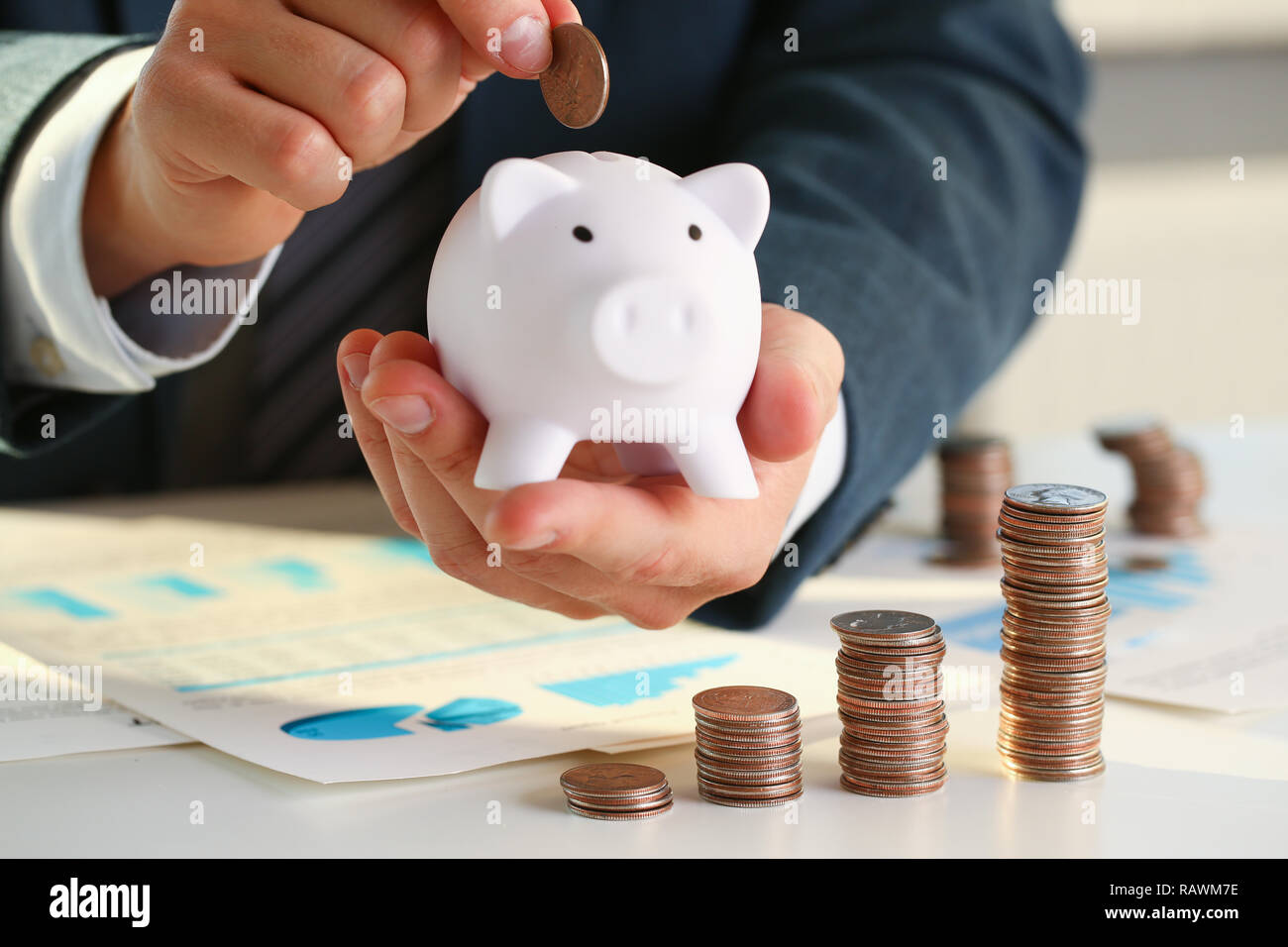 Hand businessman putting pin money into pig Stock Photo - Alamy
