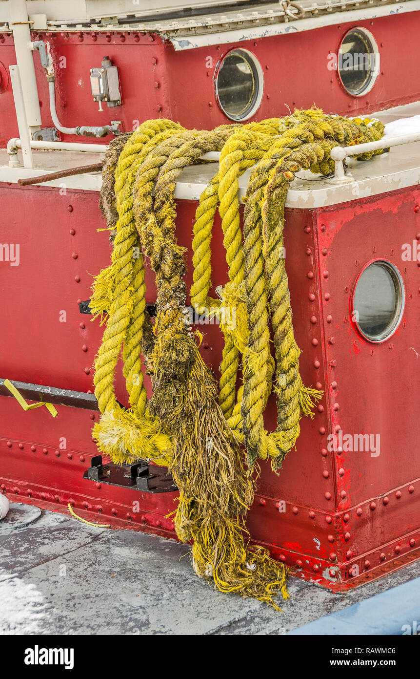 Close-up of yellow ropes on a red tugboat with a bit of snow Stock ...