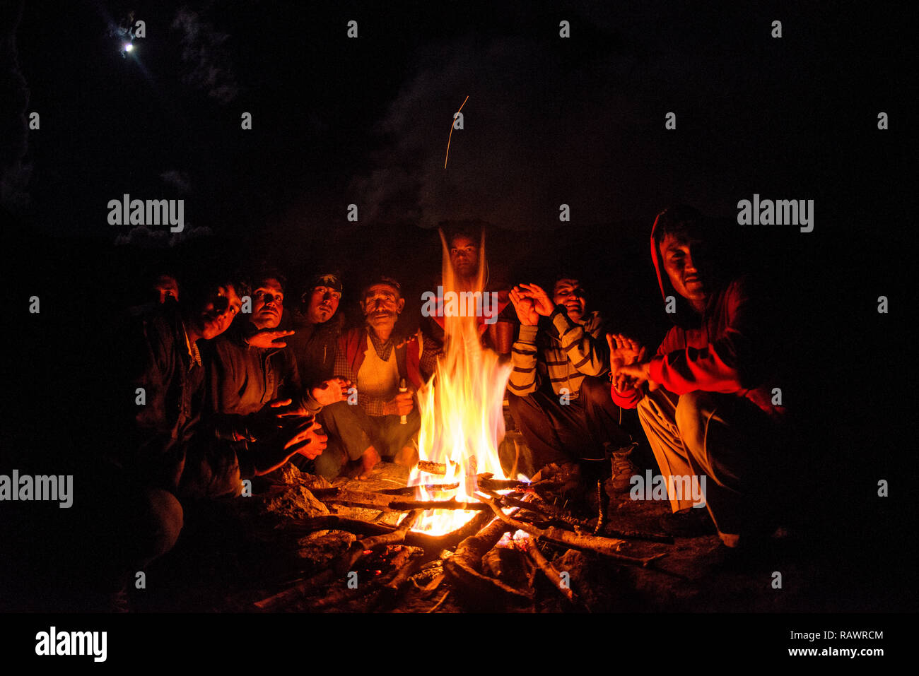 A group of porters gather around a campfire on Khalia Top above the ...