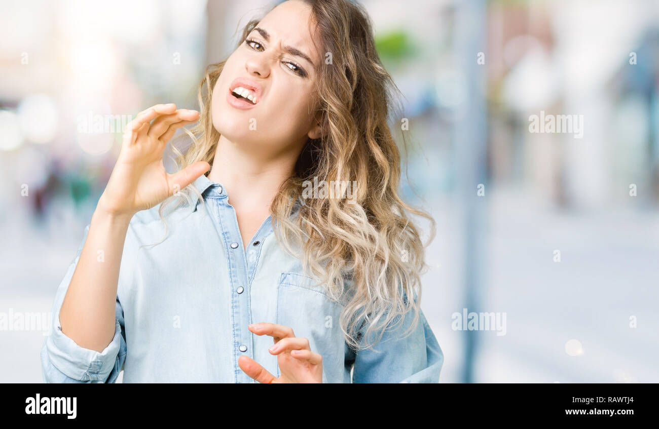 Beautiful young blonde woman over isolated background disgusted ...