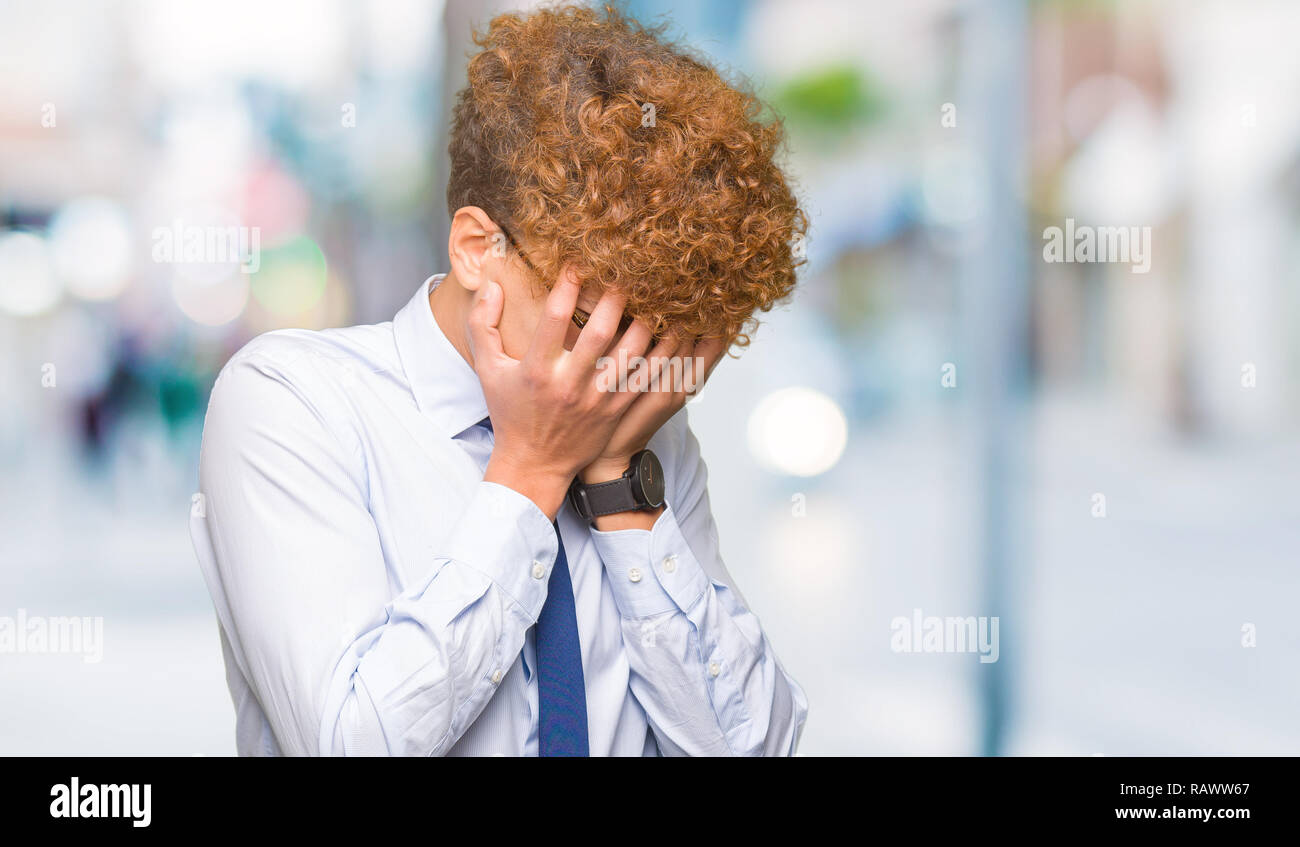 Young handsome business man with afro wearing glasses with sad ...