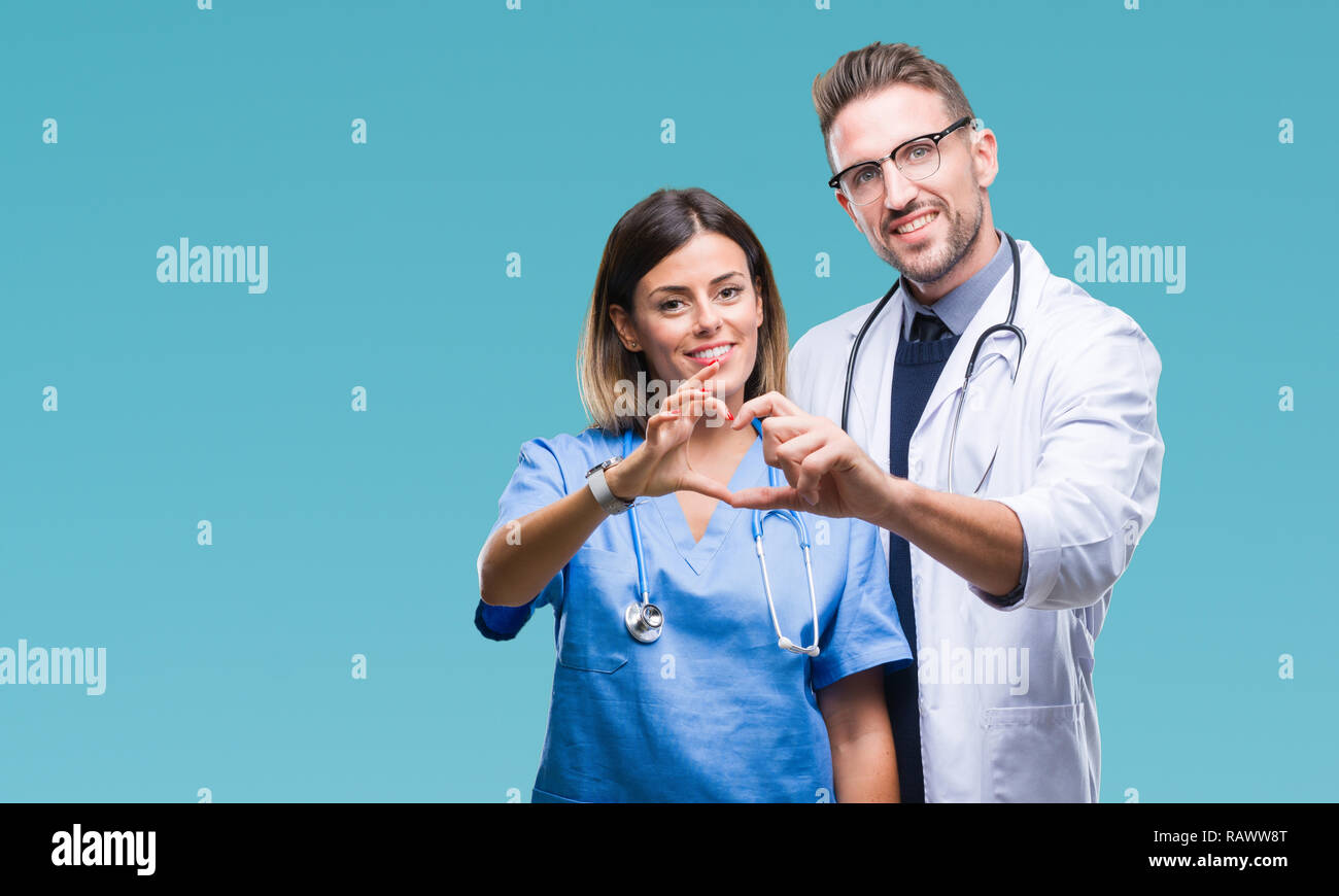 Young couple of doctor and surgeon over isolated background smiling in ...