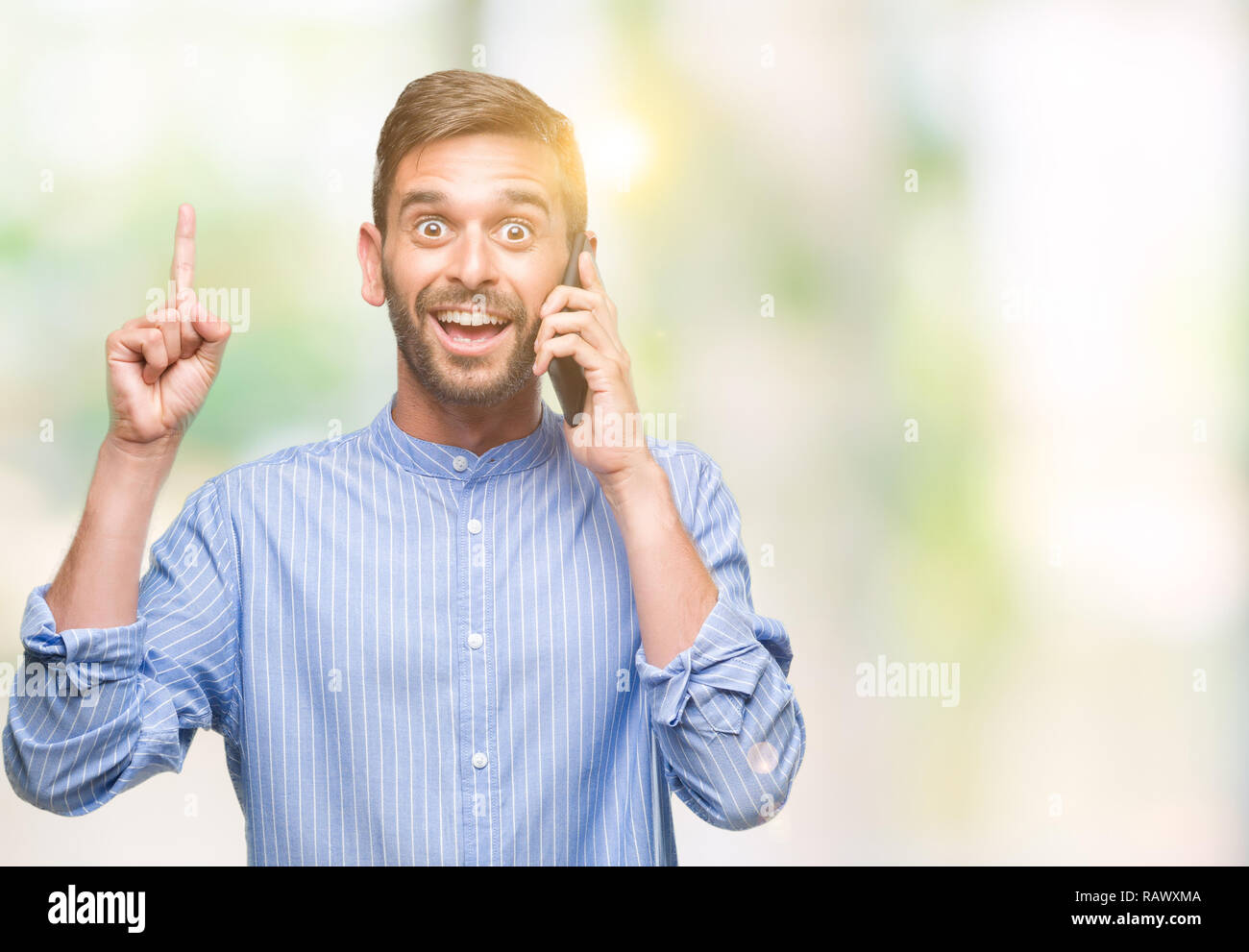Young handsome man speaking on the phone over isolated background ...