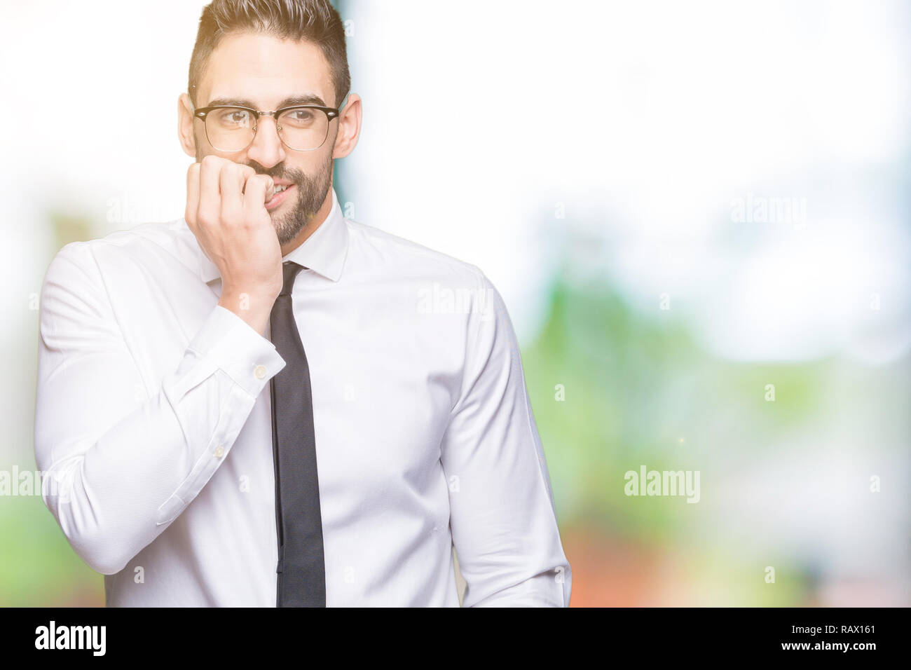 Young handsome business man wearing glasses over isolated background ...
