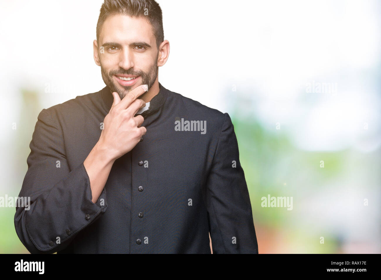 Young Christian priest over isolated background looking confident at ...