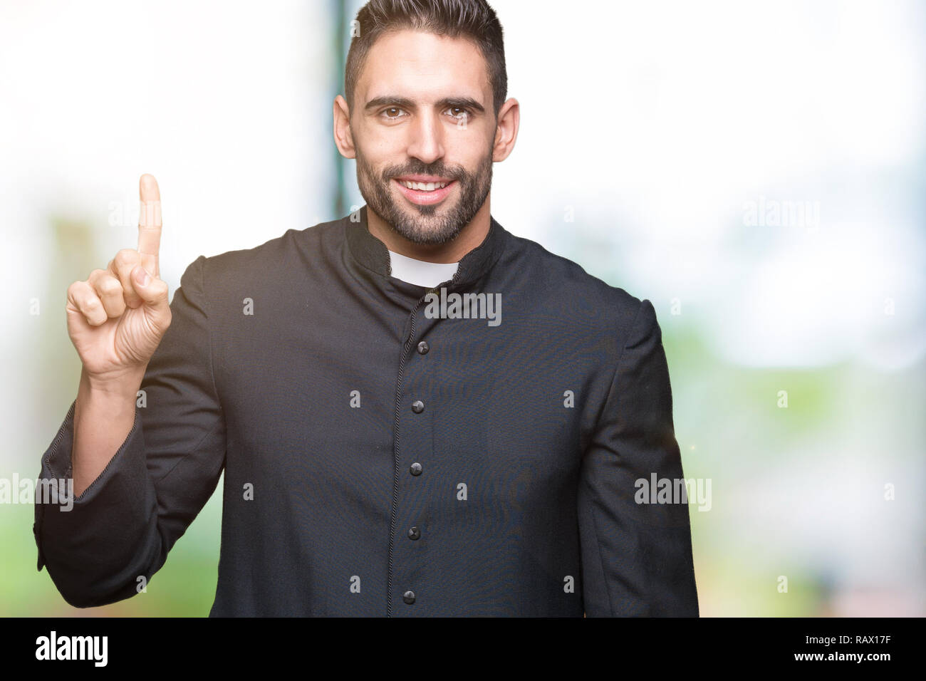 Young Christian priest over isolated background showing and pointing up ...