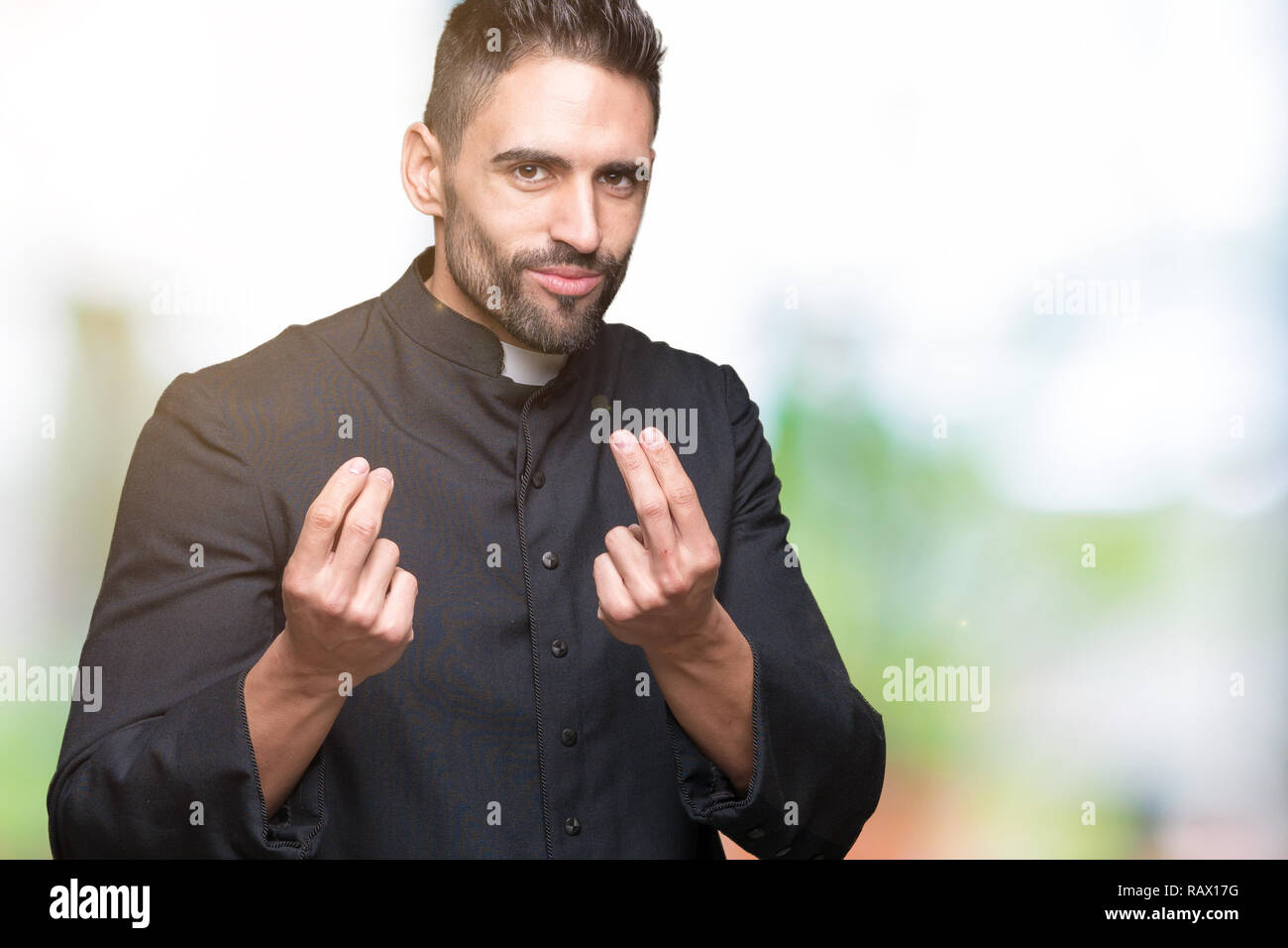 Young Christian priest over isolated background Doing money gesture ...