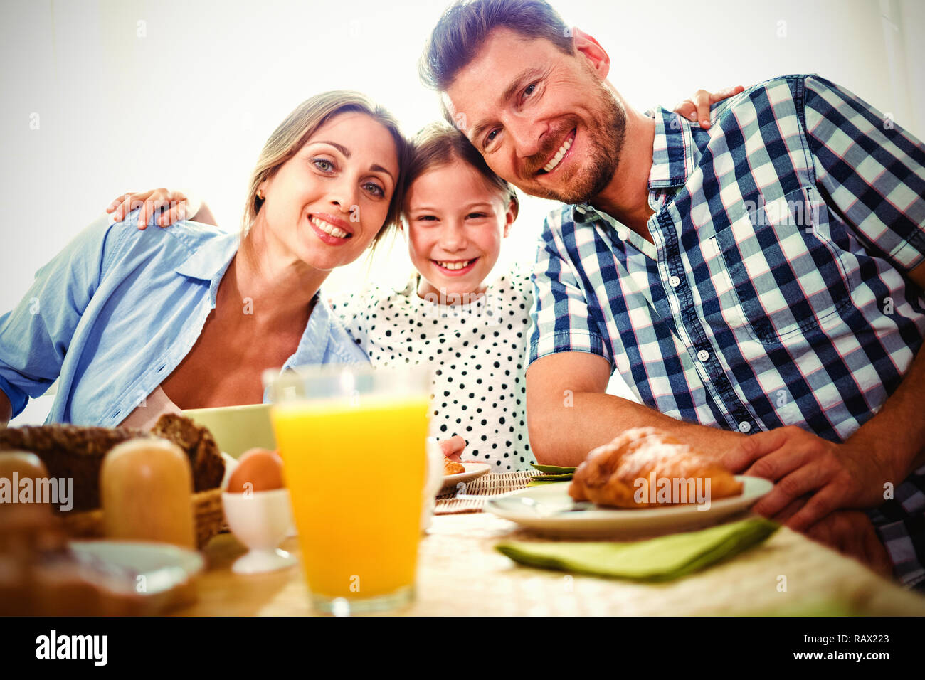 Portrait of happy family having breakfast together Stock Photo - Alamy