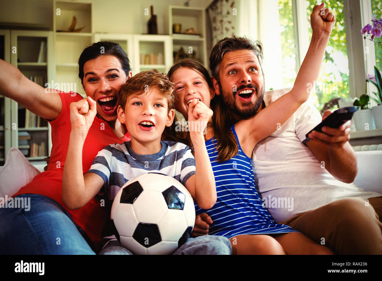 Excited family watching football match Stock Photo - Alamy