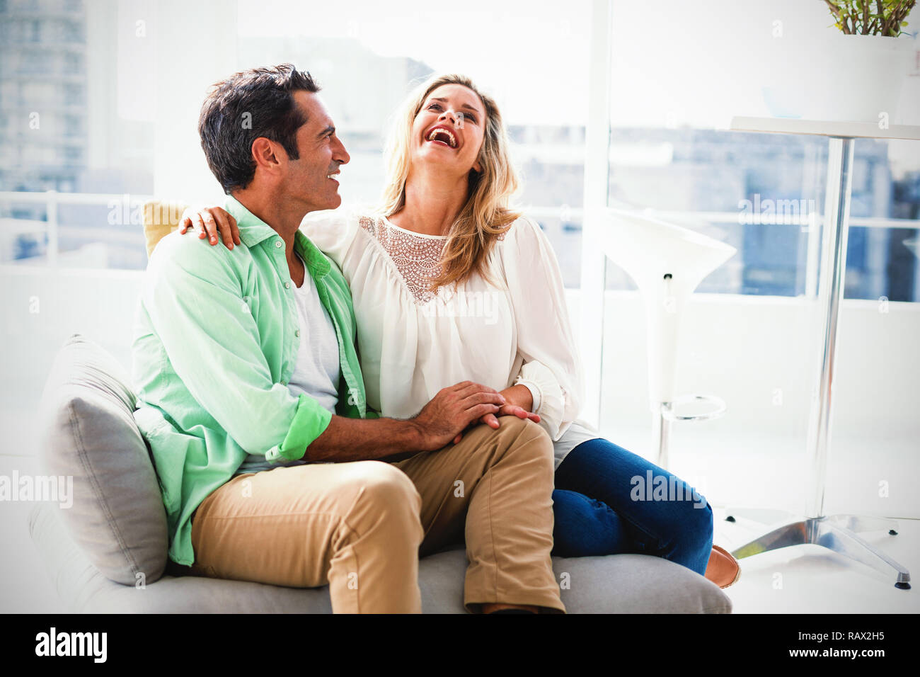Couple relaxing on sofa at home Stock Photo - Alamy
