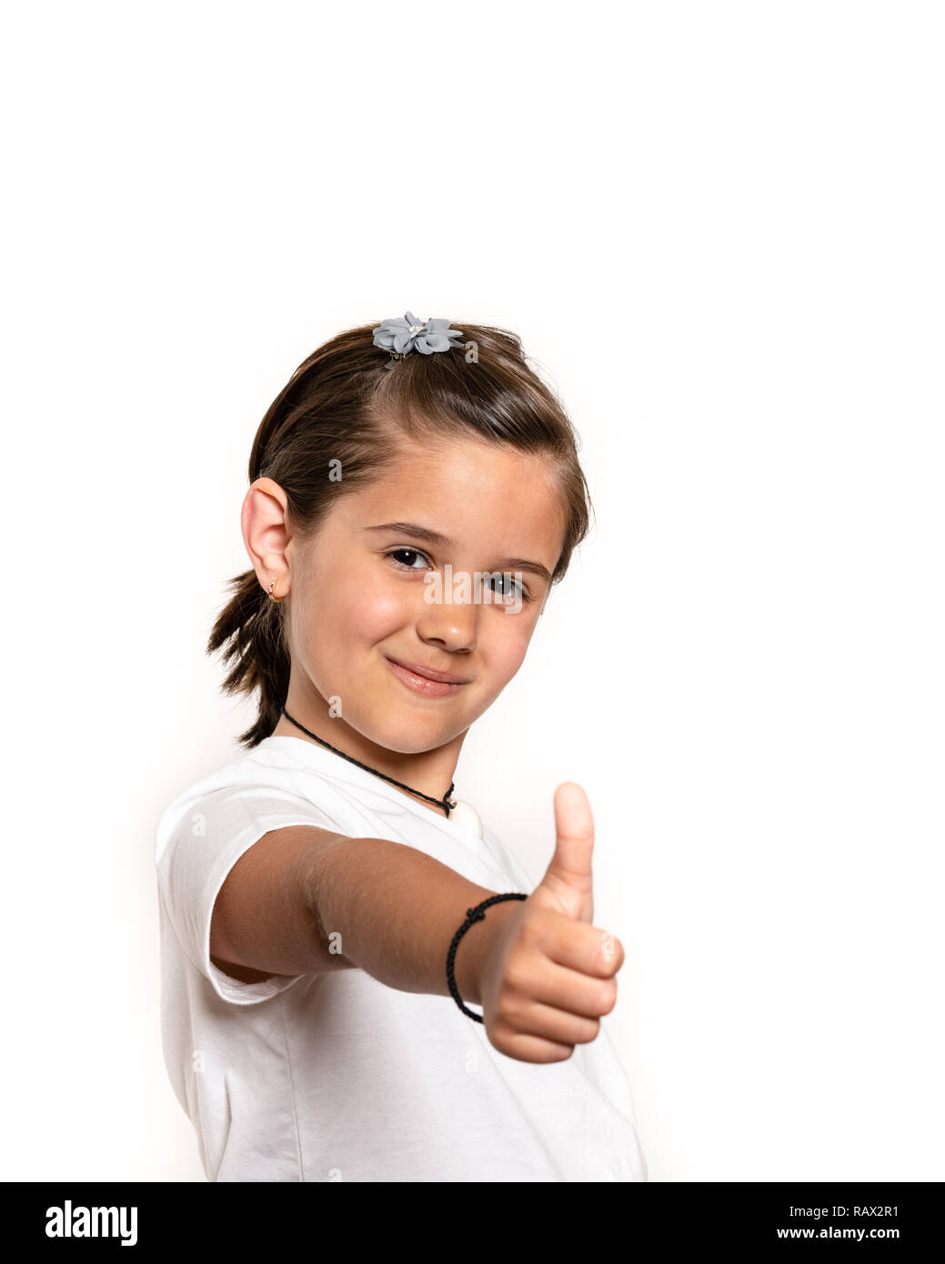 Young primary school aged school girl showing thumbs up. Focus on face ...