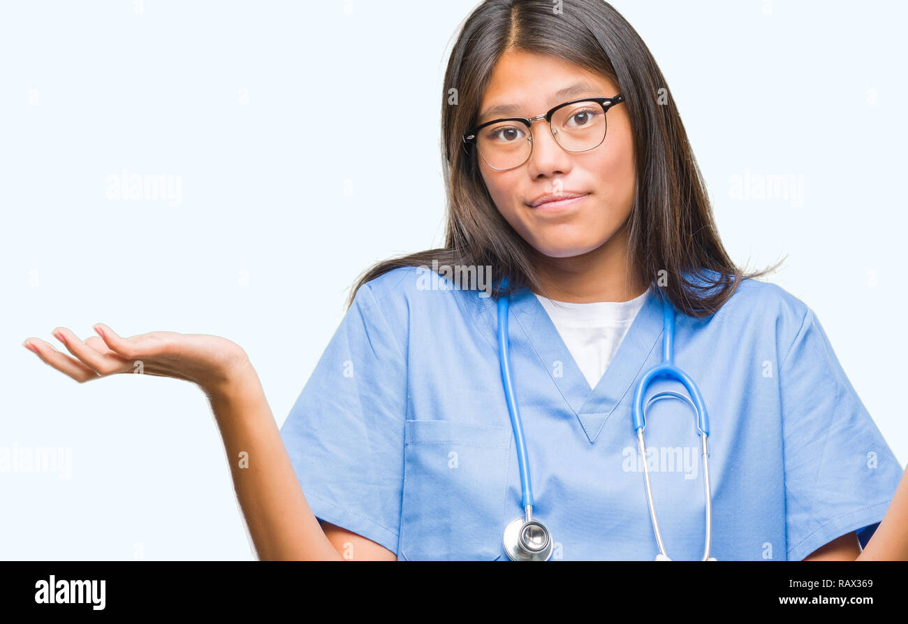 Young asian doctor woman over isolated background clueless and confused ...