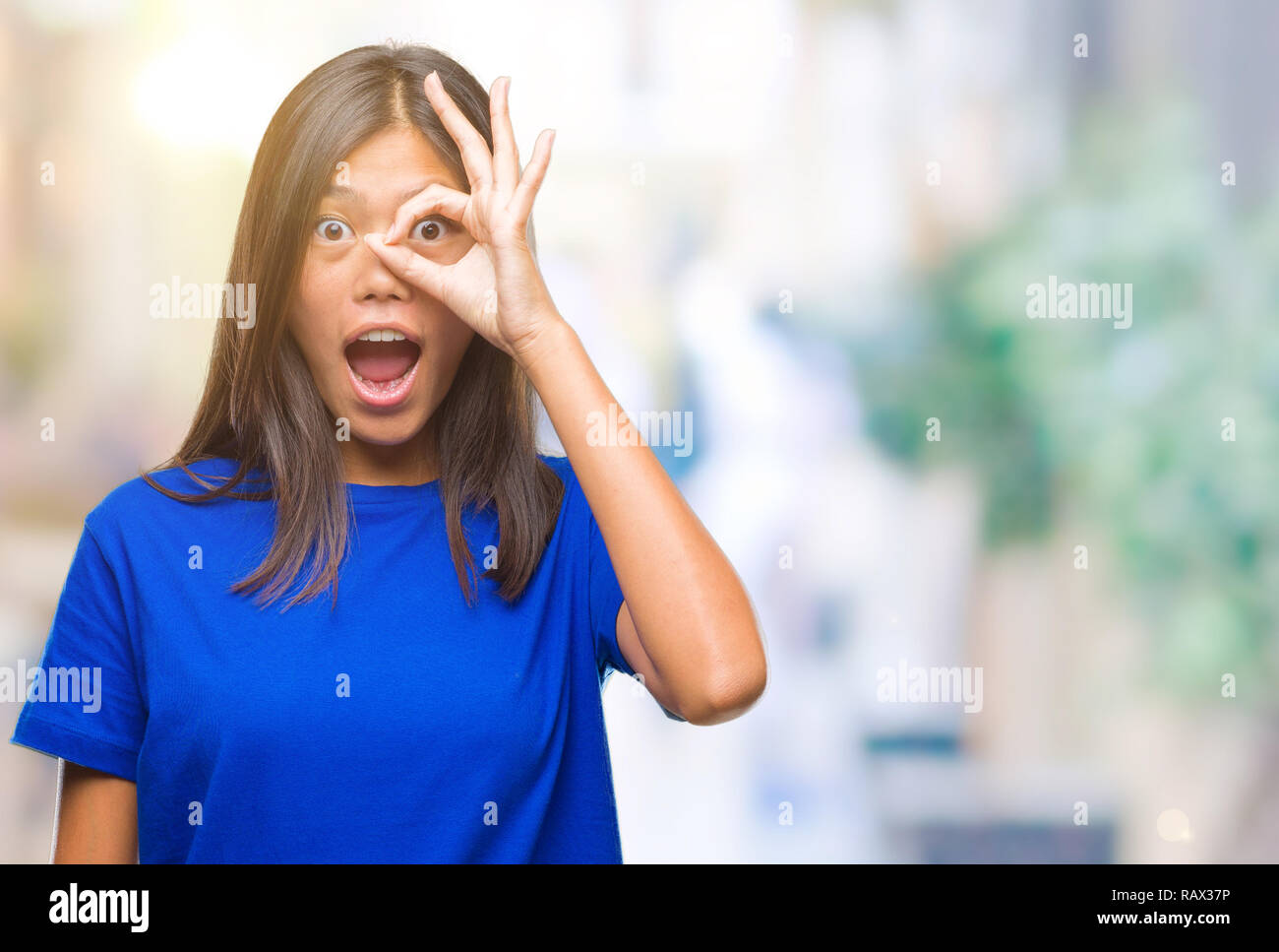 Young asian woman over isolated background doing ok gesture shocked ...