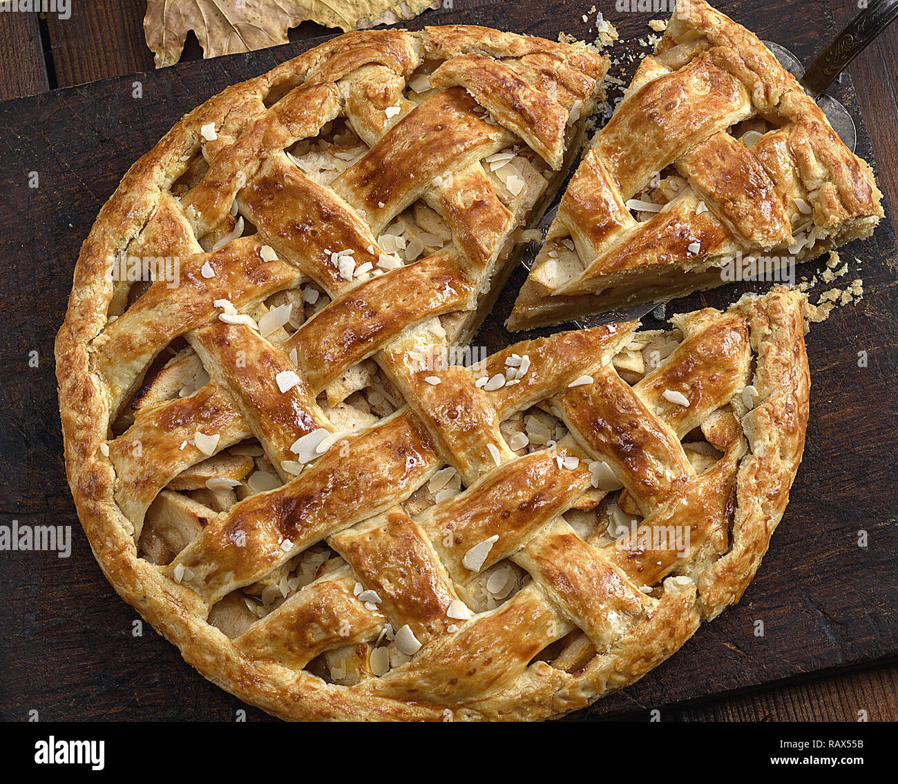 baked whole round apple pie on a brown wooden board, puff pastry, top ...