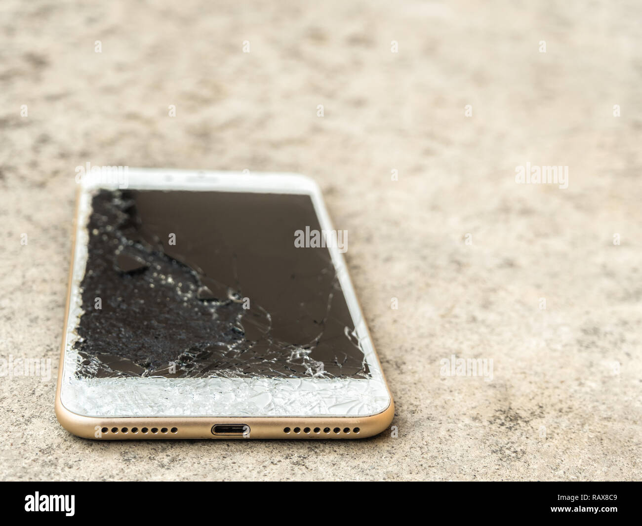 Close up of broken mobile phone drop on cement floor with copy space ...