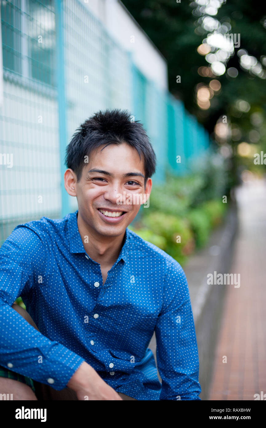 Asian male model poses for pictures on the street Stock Photo - Alamy