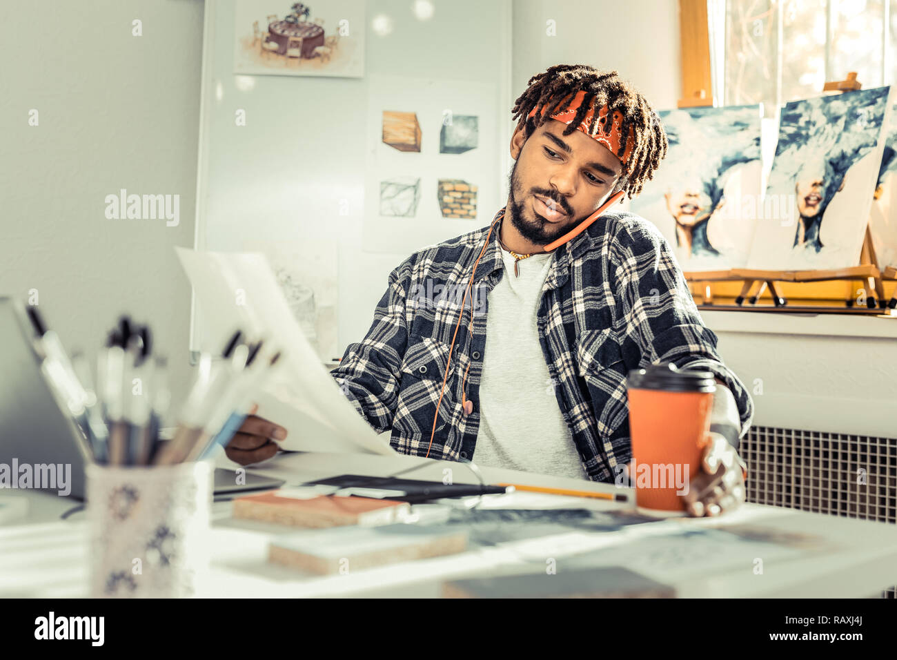 Modern interior designer speaking by phone with his client Stock Photo ...