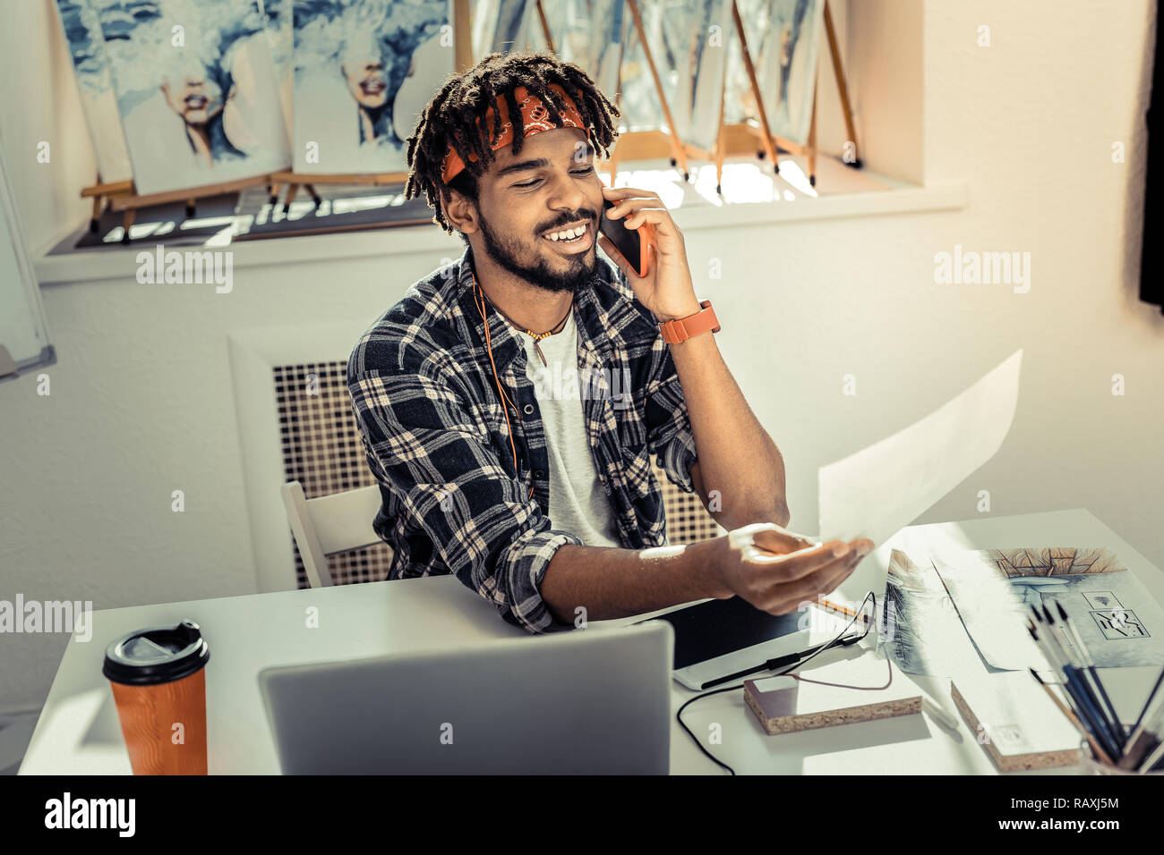 Modern artist wearing red smart watch holding paper with painting Stock ...