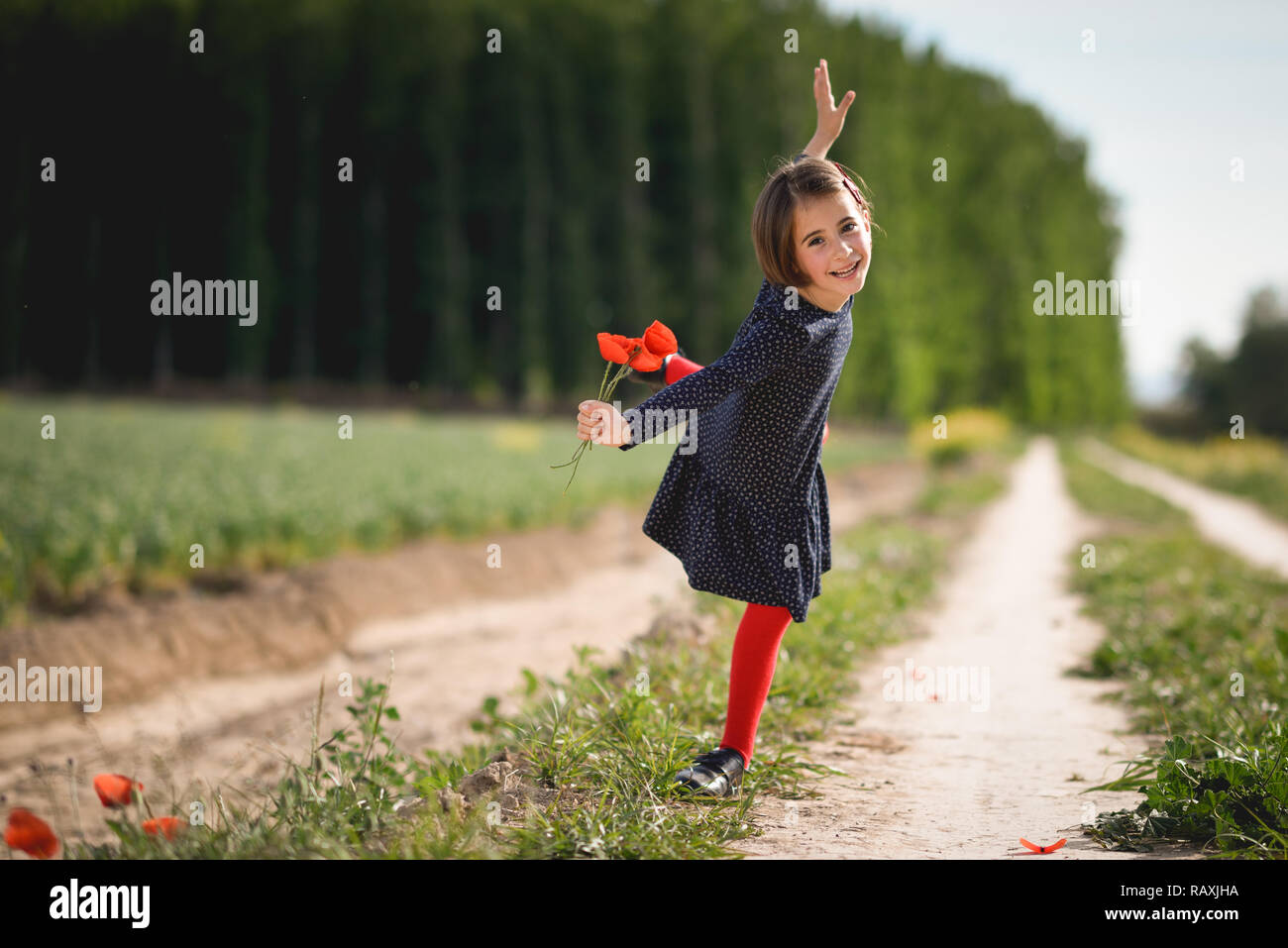 Little girl walking in nature field wearing beautiful dress with ...