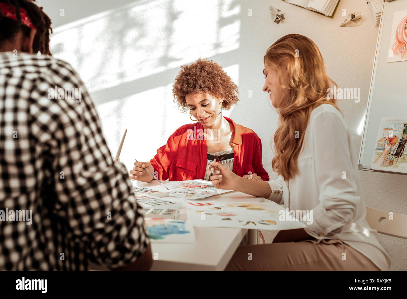 Slim appealing artist wearing beige trousers and white blouse Stock ...