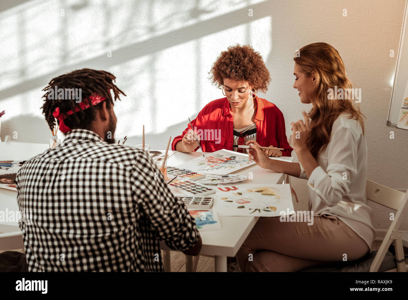 Team of three talented inspired artists drawing together Stock Photo ...