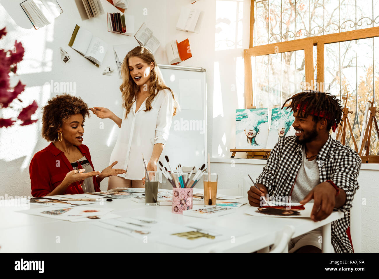 Two stylish art students feeling amazing while talking to teacher Stock ...