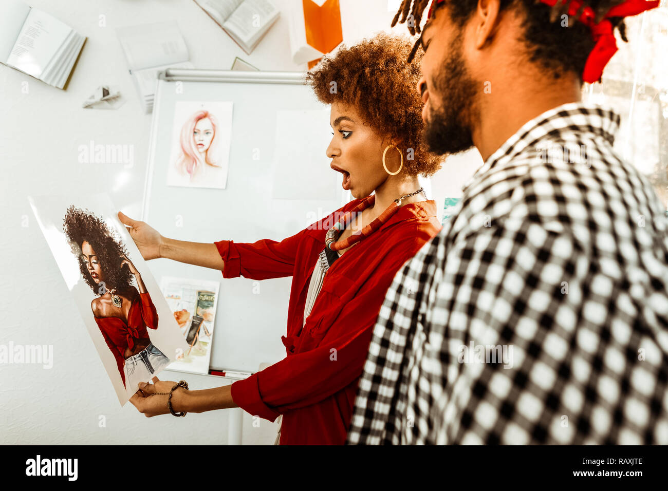 Appealing woman feeling very surprised seeing her amazing portrait ...