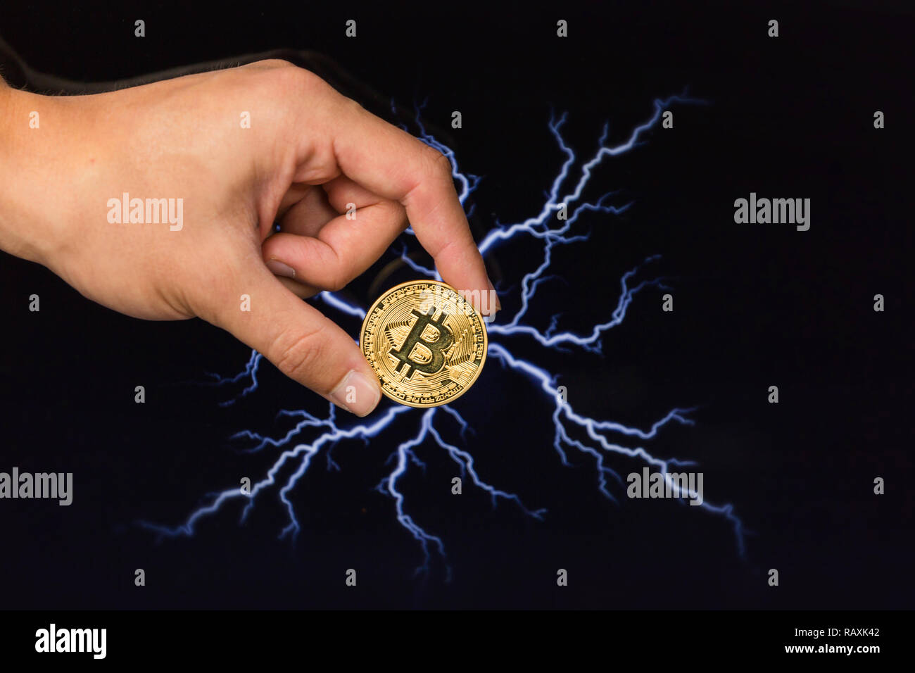 Man holding Bitcoin gold coin in front of lightning network concept ...
