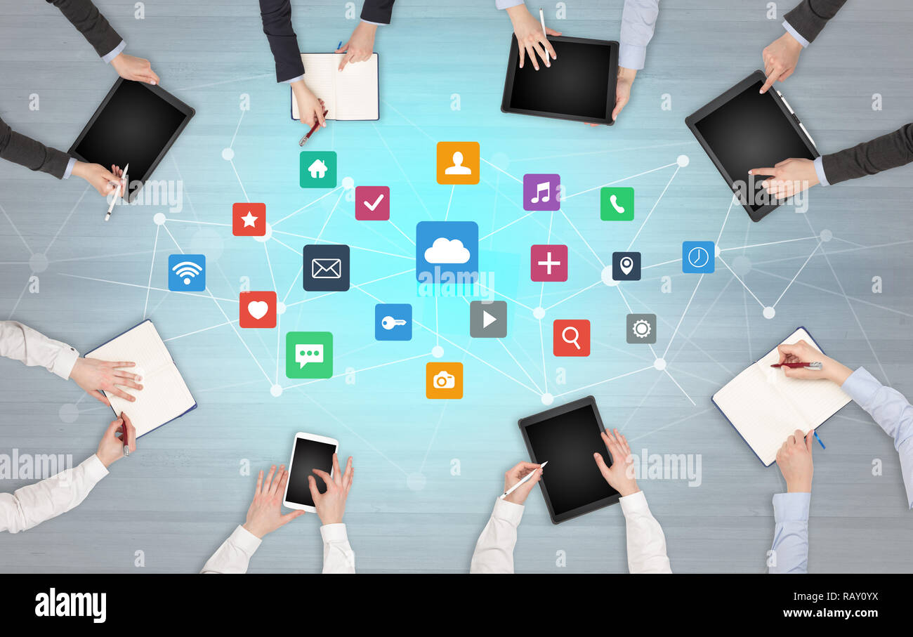 Group of people with devices in hands working in team on tablets ...