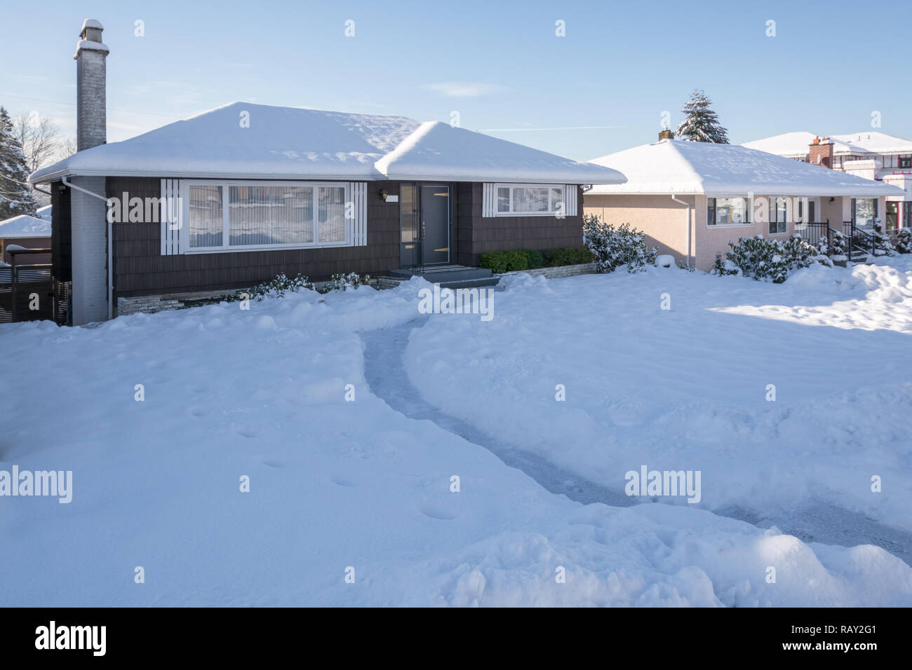 Pathway over front yard leading to average house cleaned from the snow ...