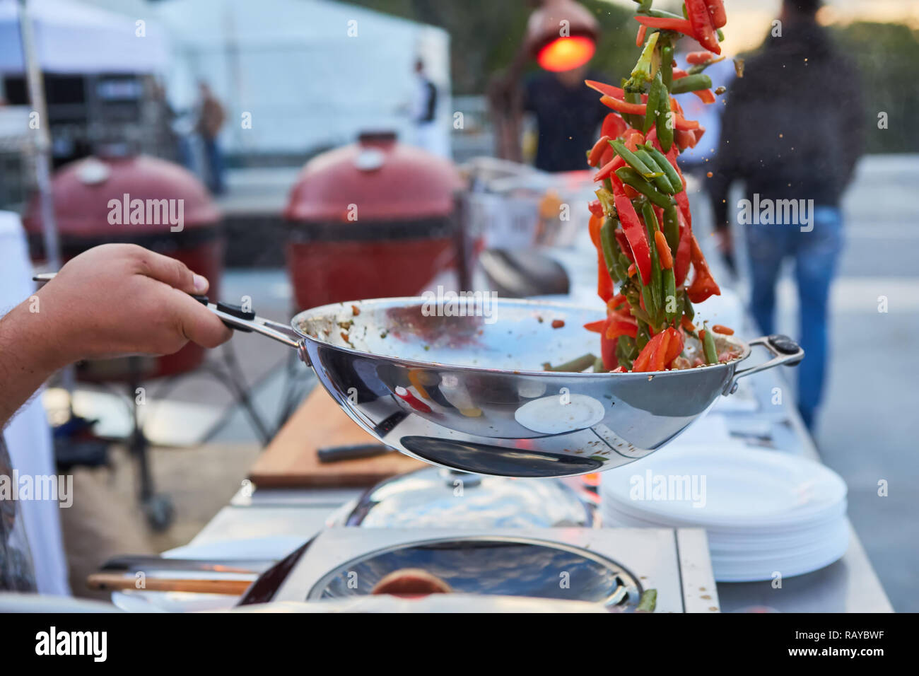 chef tossing vegetables in a wok in an outdoor kitchen Stock Photo - Alamy