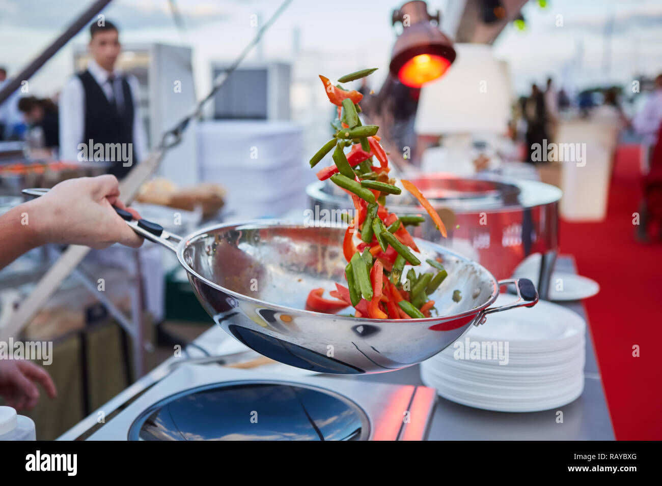 chef tossing vegetables in a wok in an outdoor kitchen Stock Photo - Alamy
