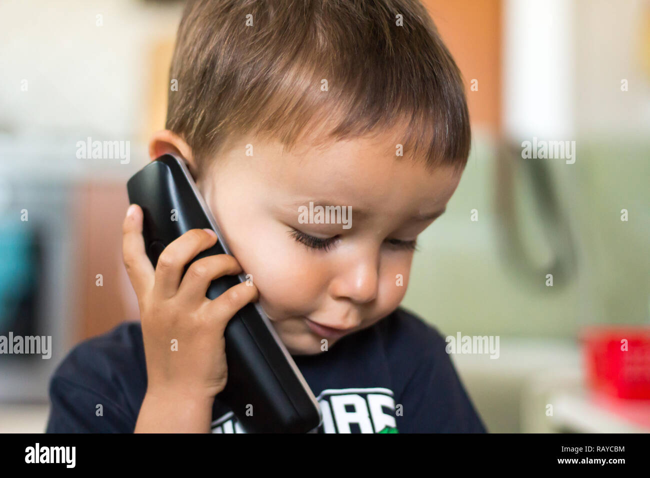 Boy child phoning at home imitating the action Stock Photo - Alamy