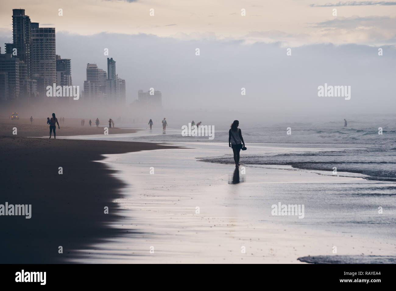 Classic summer beach scene in Surfers Paradise with peoples silhouettes ...