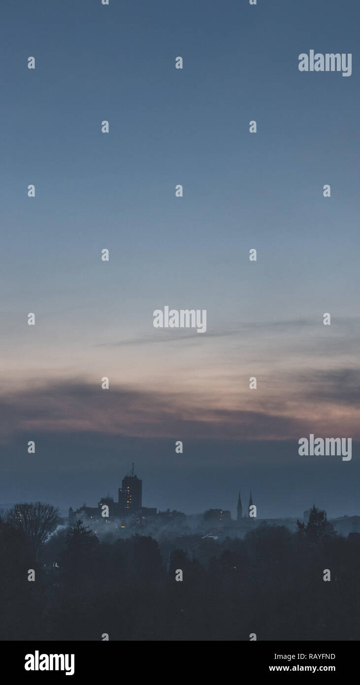Dim winter twilight. Clouds at sunset over dark industrial town Stock ...