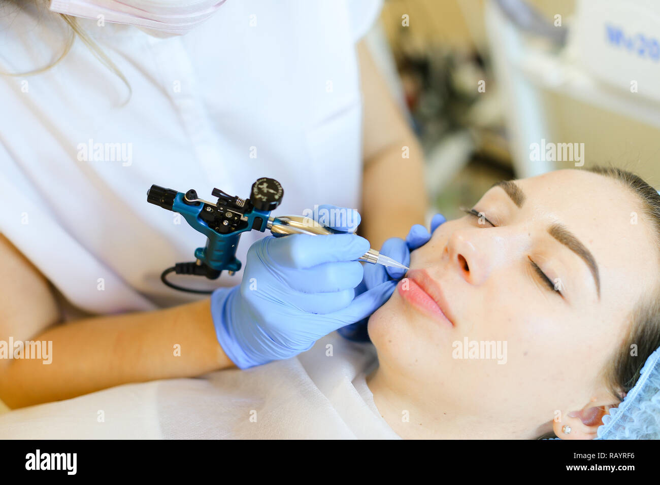 Close up hand making permanet lip tattoo with microblading device at ...