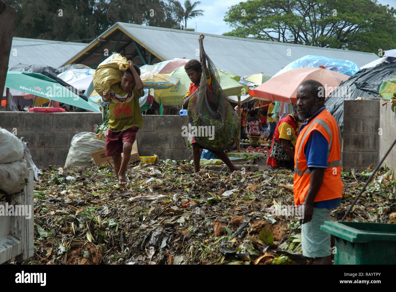 Children clearing up piles of discarded fruit and vegetables, at Boroko ...