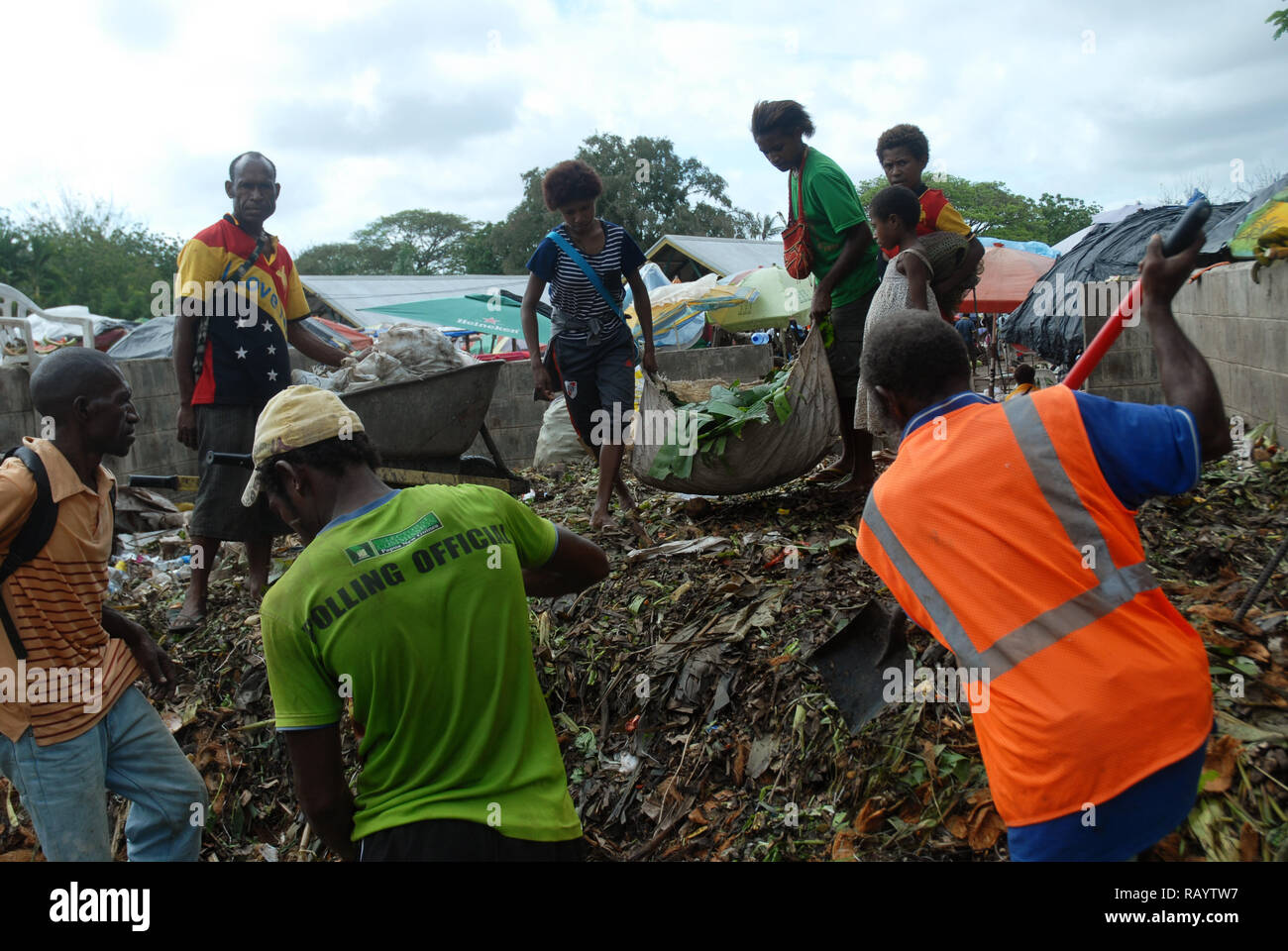 Children clearing up piles of discarded fruit and vegetables, at Boroko ...