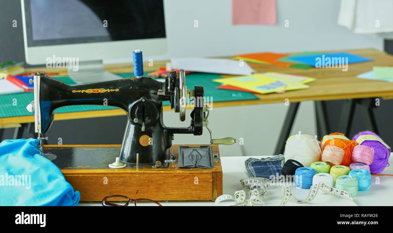 Retro sewing machine on designer clothes desktop Stock Photo - Alamy