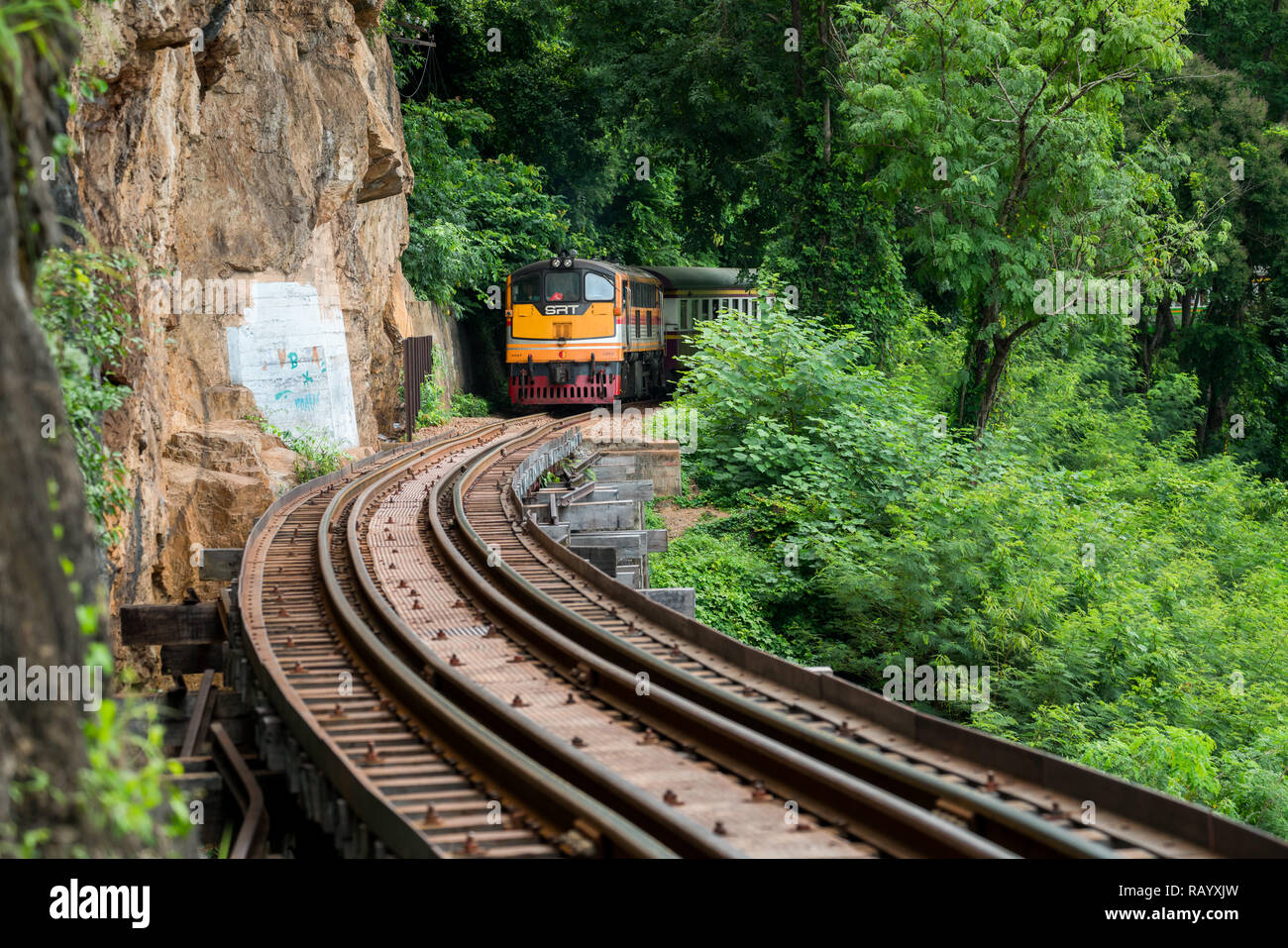 Old railroad tracks on bridge beside cliff rock Stock Photo - Alamy