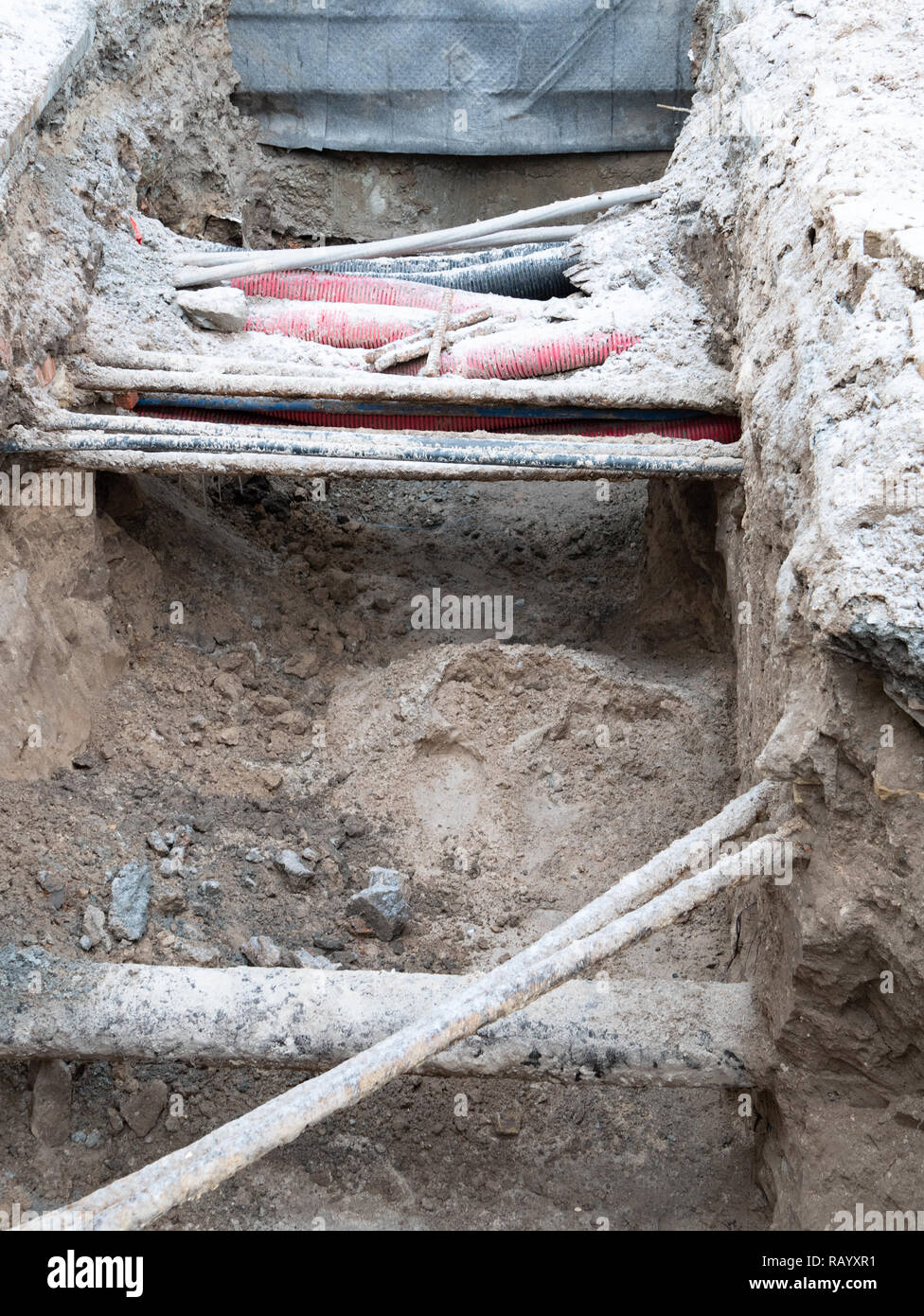water and electrical pipes in ground pit trench ditch during plumbing ...
